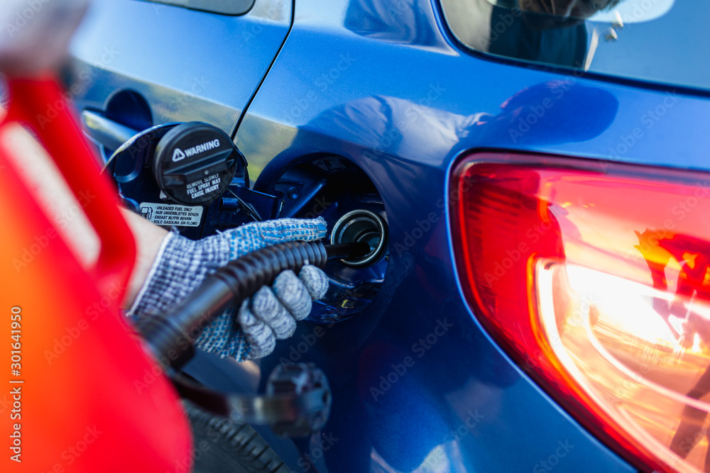 Filling the machine from the canister into the neck of the fuel tank ...