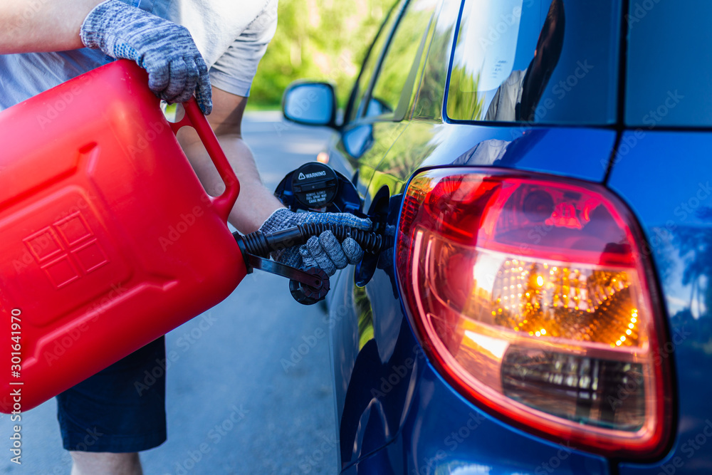 Filling the machine from the canister into the neck of the fuel tank ...