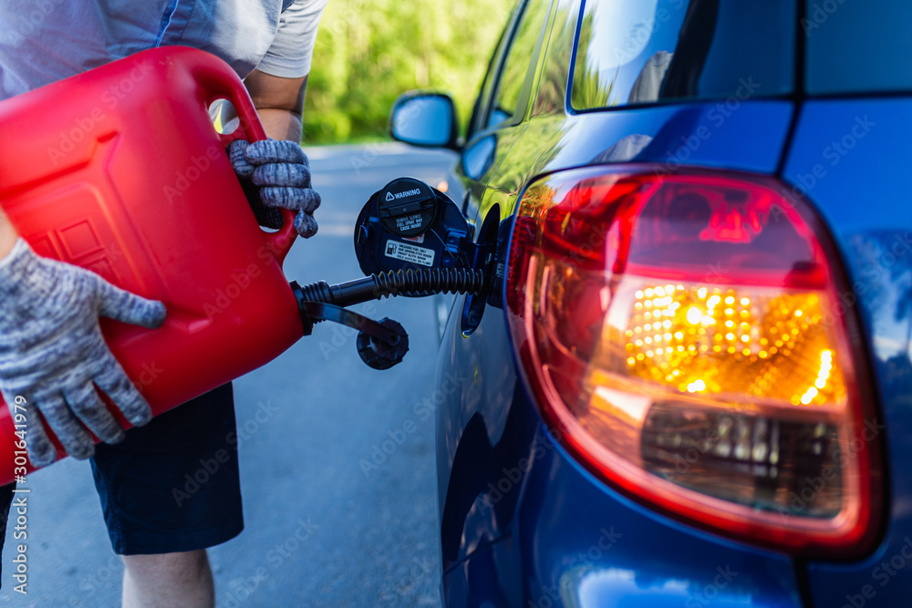 Filling the machine from the canister into the neck of the fuel tank ...