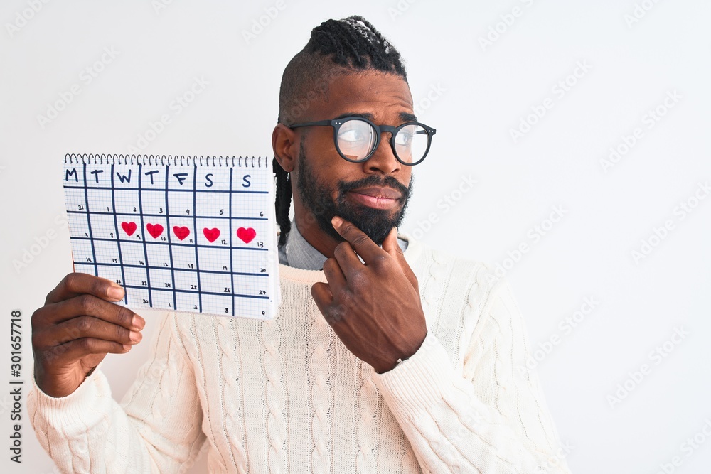 African american man with braids holding period calendar over isolated ...