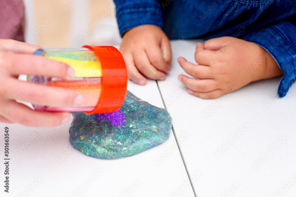 Process of making slime. Children playing with blue magic glitter slime ...