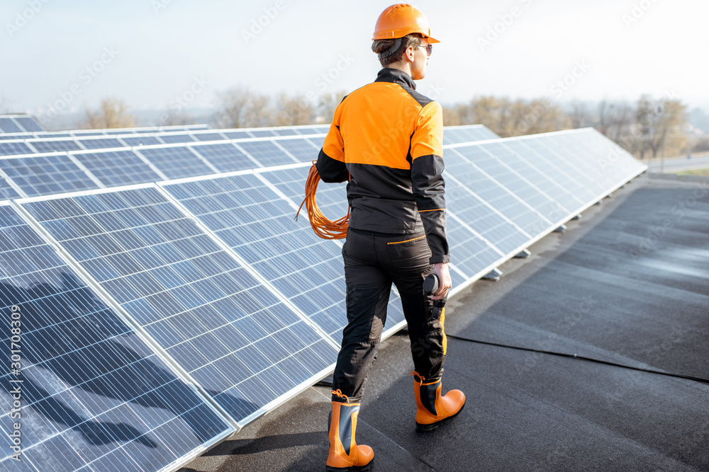Well-equipped worker in protective orange clothing walking and ...