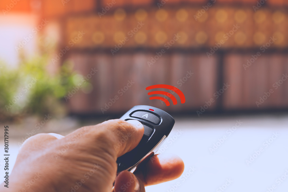 Foto de Man hand using remote control to open the automatic gate while ...