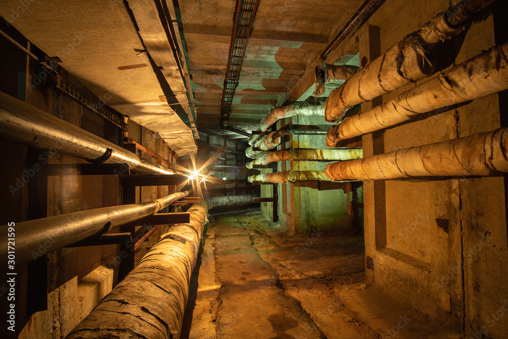 Underground concrete utility tunnel with pipes and wires. This tunnel ...