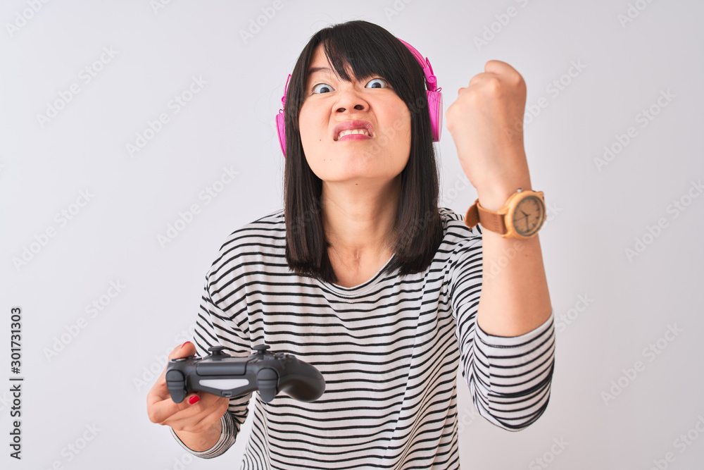 Chinese gamer woman playing video game using headphones over isolated ...