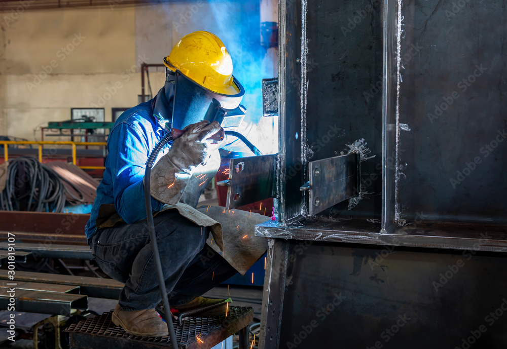 The welder is welding a column steel structure work with process Flux ...