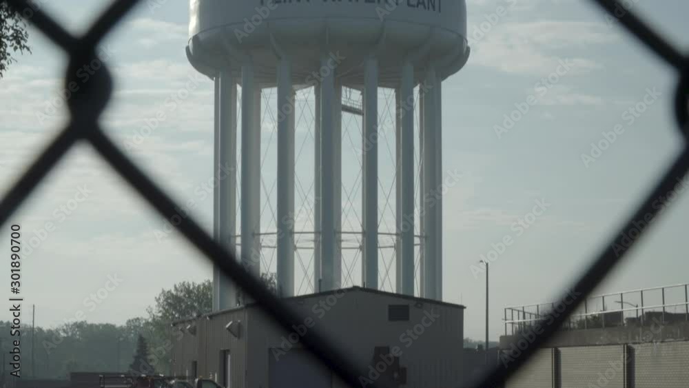 A wide shot of the Flint, Michigan Water Plant water tower, as seen ...