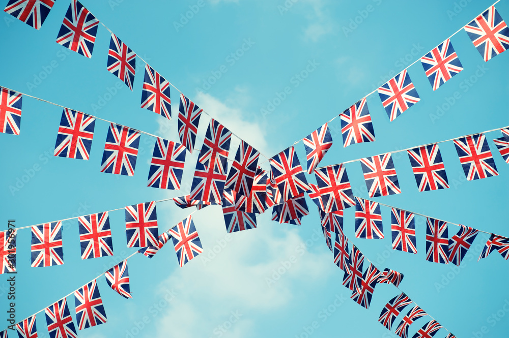 British Union Jack flag bunting strung across soft blue sky Stock Photo ...