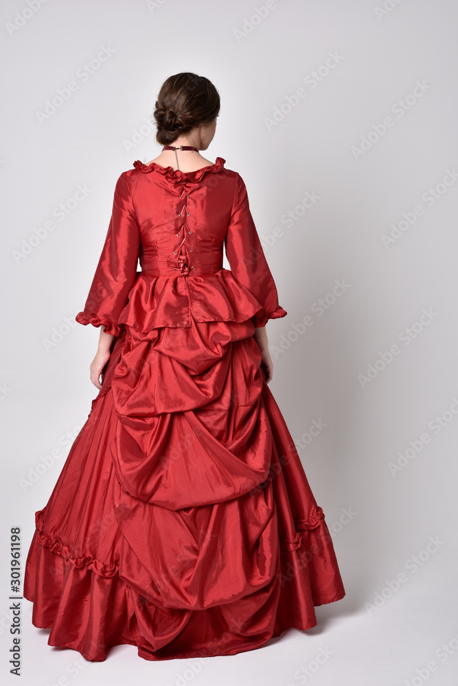 full length portrait of a brunette girl wearing a red silk victorian ...