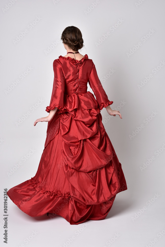 full length portrait of a brunette girl wearing a red silk victorian ...