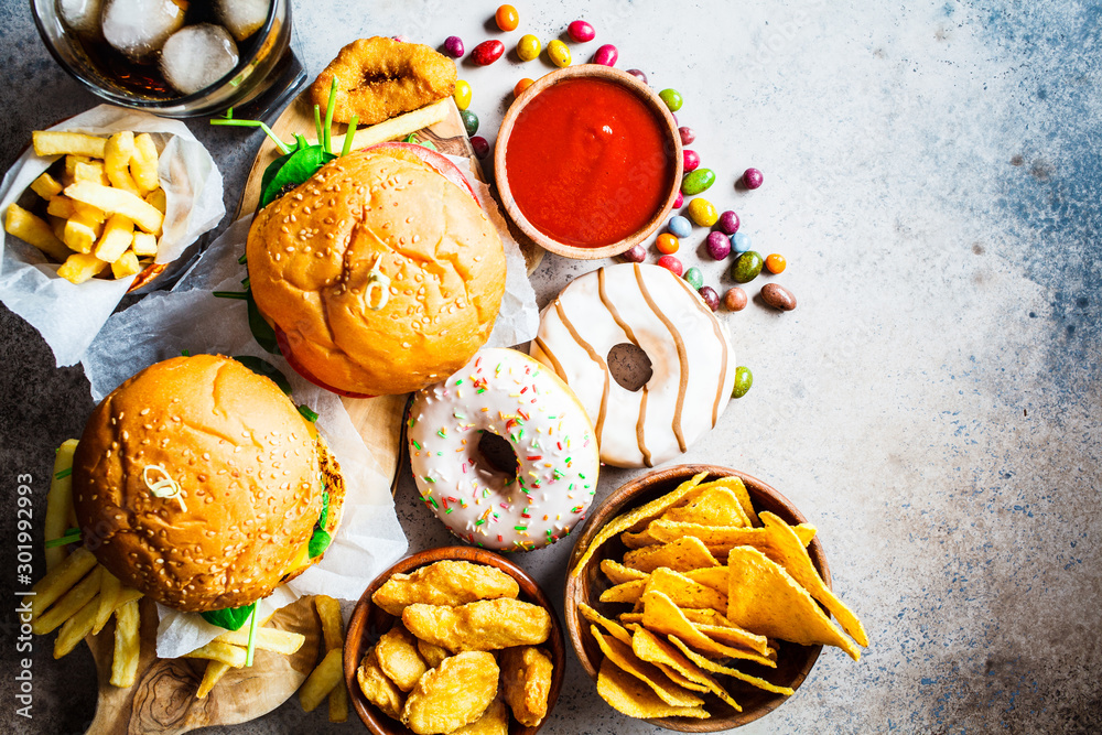 Assortment of fast food. Junk food background. Cheeseburgers, french ...