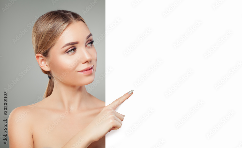 Young perfect model woman with clear skin holding empty white card ...