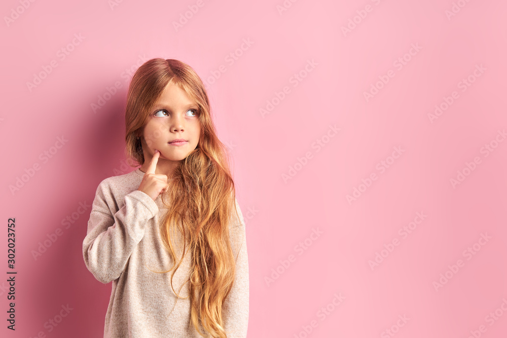 Portrait of sweet adorable girl thinking isolated over pink background ...