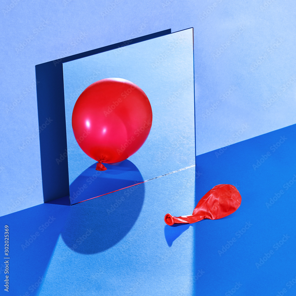 Still life space with a deflated balloon reflected on a swollen state ...
