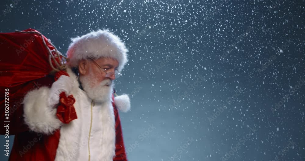 Santa Walking through snow, carrying a bag full of presents, then ...
