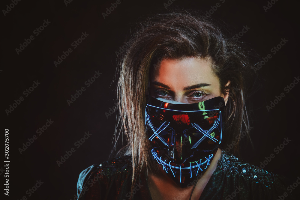 Foto de Pretty woman with weird mask on her face is posing for ...