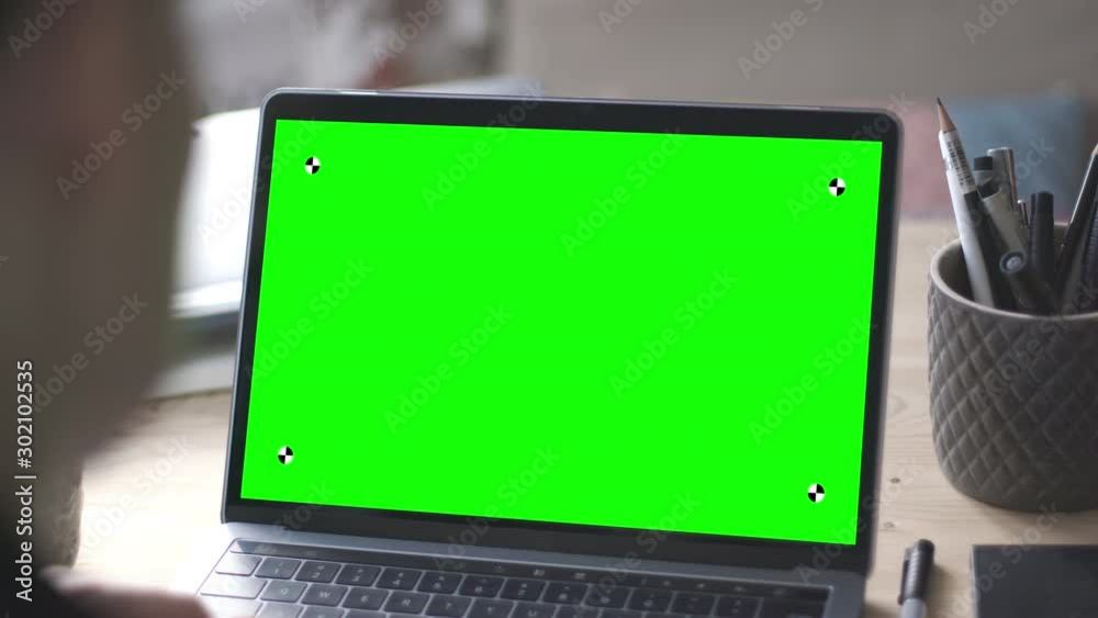 Over the shoulder shot of young woman working on modern laptop with ...