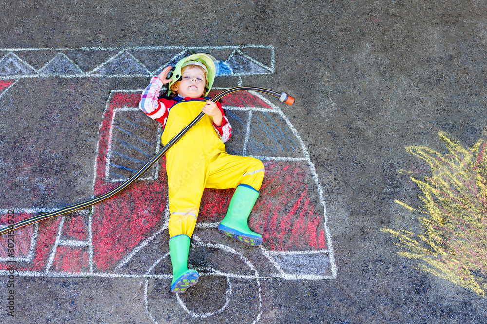 Fotografia do Stock: Little kid boy in fireman uniform having fun with ...
