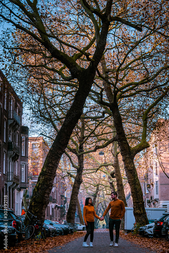 Autumn in Amsterdam, couple walking at street in Amsterdam with leaning ...