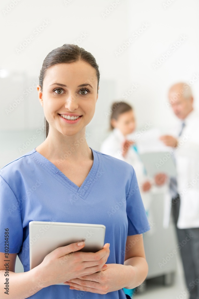 Attractive nurse standing in clinic Stock Photo | Adobe Stock