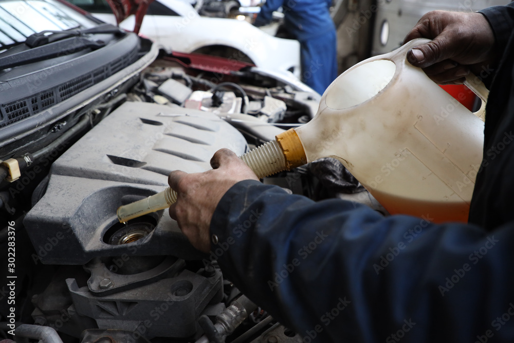 oil change in a car, a mechanic pours oil into an engine Stock Photo ...