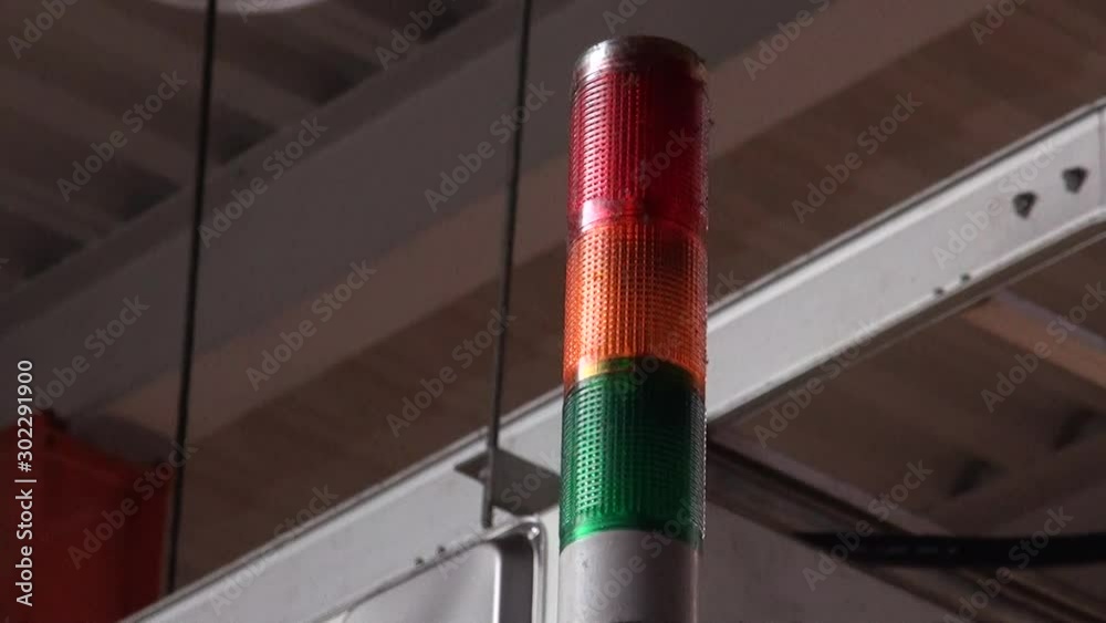 A flashing red light comes on in a factory to indicate to employees ...