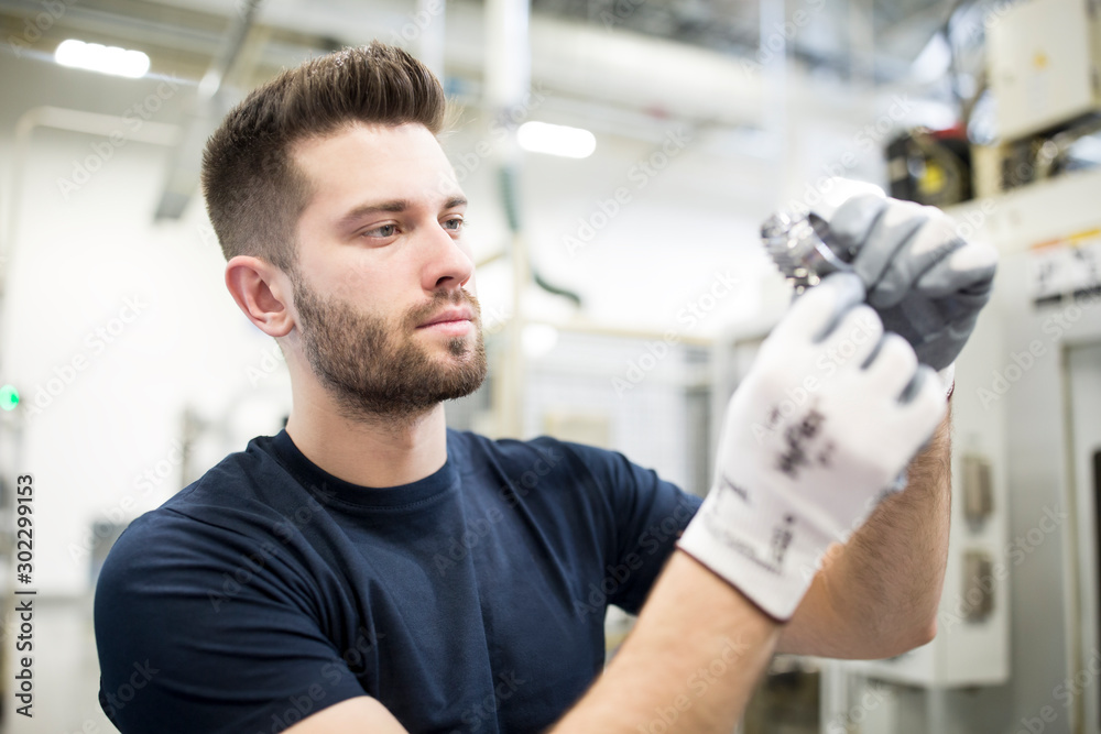 Man examining workpiece in a factory Stock Photo | Adobe Stock