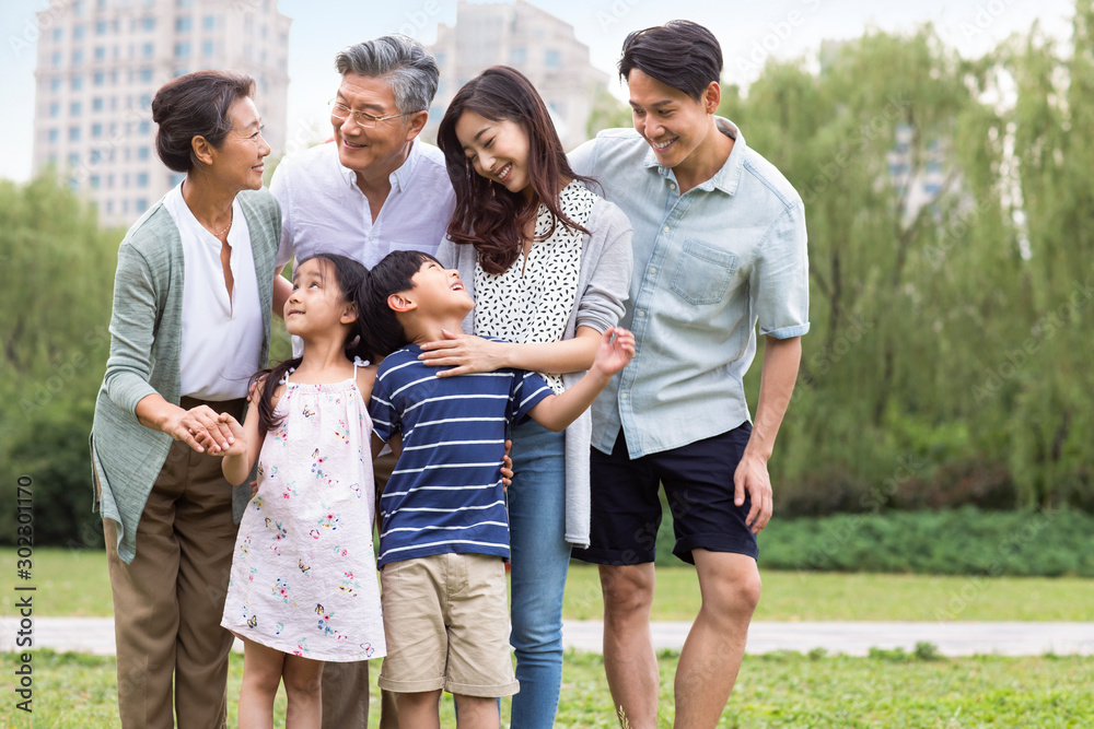 Happy Chinese family standing on grass Stock Photo | Adobe Stock