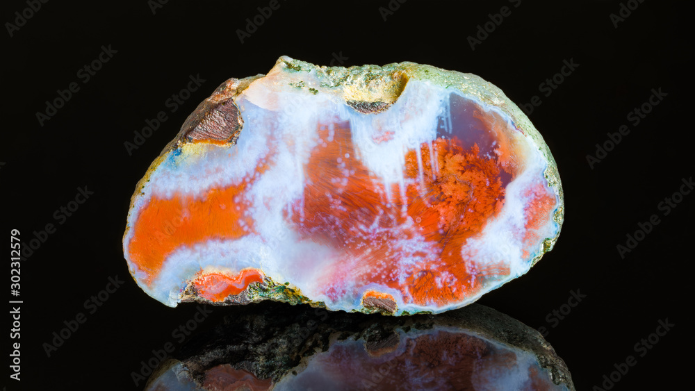 Polished agate precious stone cross section with reflection on black ...