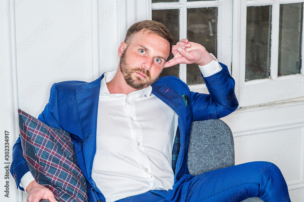 Young tired man with beard, relaxing, thinking inside at home in New ...