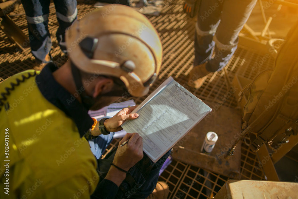 Construction miner supervisor wearing white safety helmet signing ...