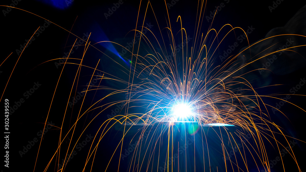 Glowing flow of steel metal welding spark dust particles shine in the ...