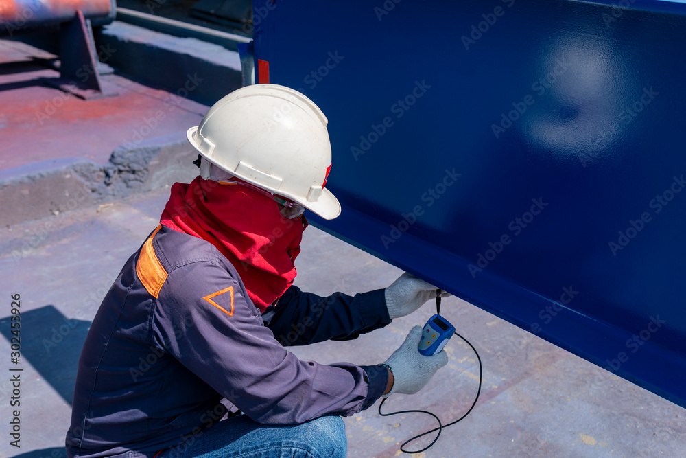 Technicians are measuring the Dry Film Thickness (DFT) for painting of ...