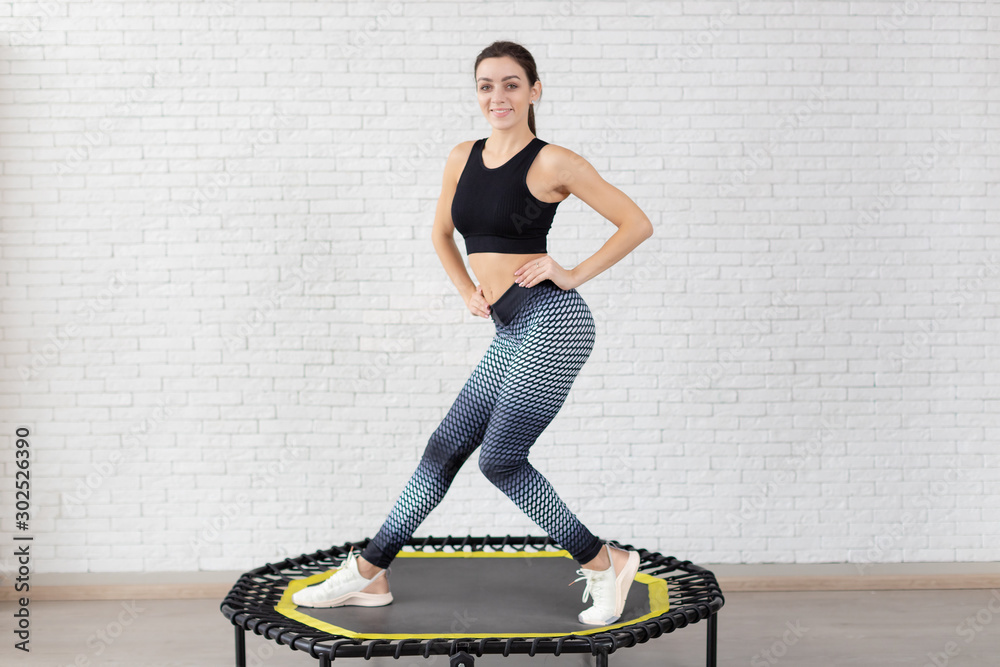 Relaxed woman jumping on trampoline.young fitness girl trains on a mini ...