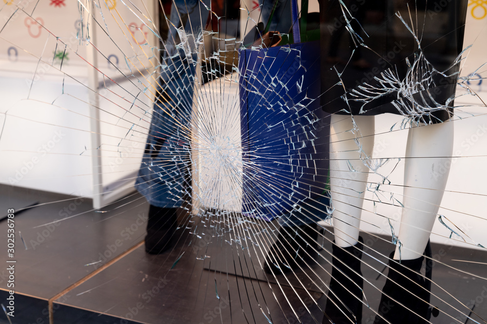 Shattered window of broken storefront store crack from impact on shop ...