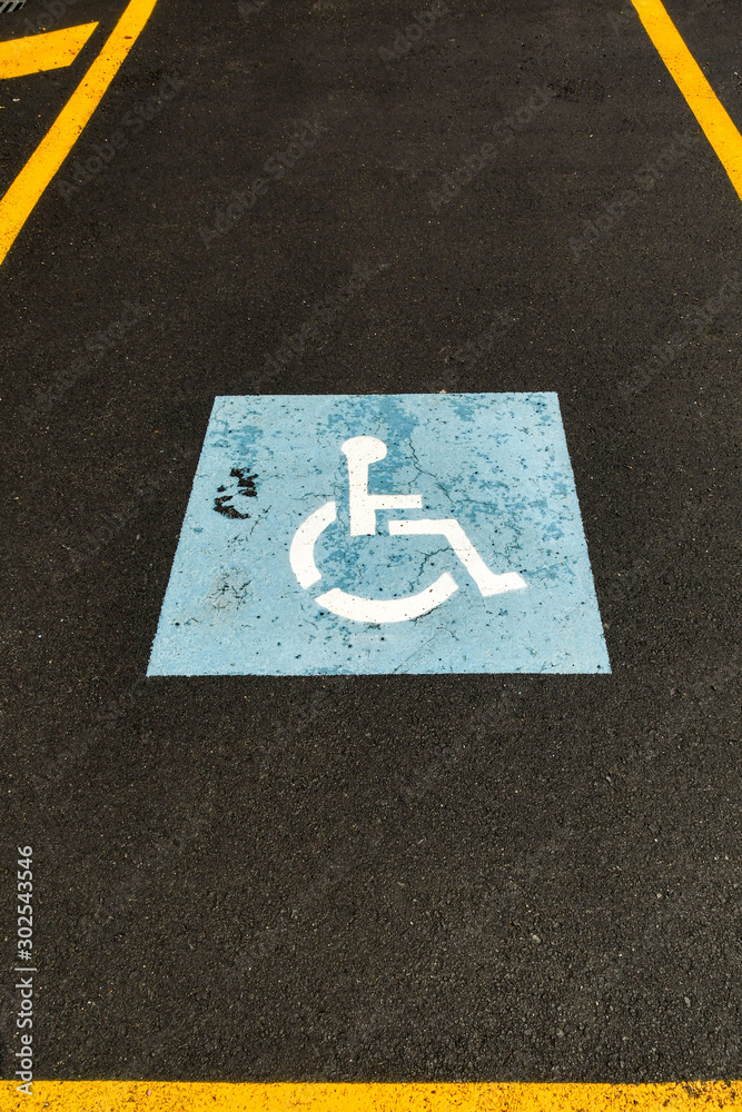 Wheelchair symbol painted on the surface of a car park to denote a car ...