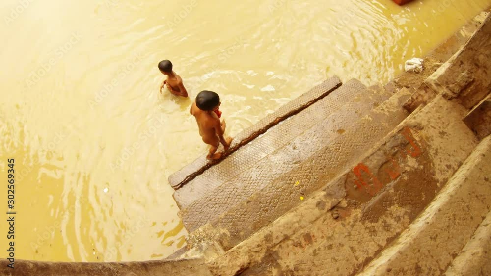 Vidéo Stock two indian boys without clothes wash themselves in dirty ...