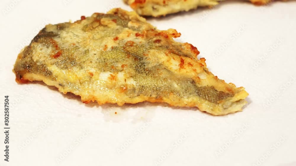 Vidéo Stock puts fish flounder on a napkin. Fried fish, dripping fat ...