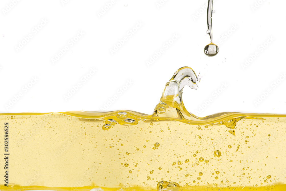 splash from pouring yellow vegetable oil in a layer on a white ...