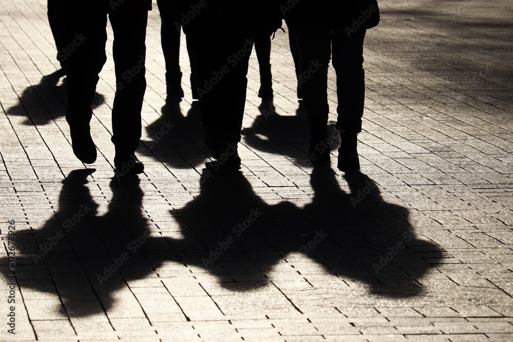 Silhouettes and shadows of people on the street. Crowd walking on ...