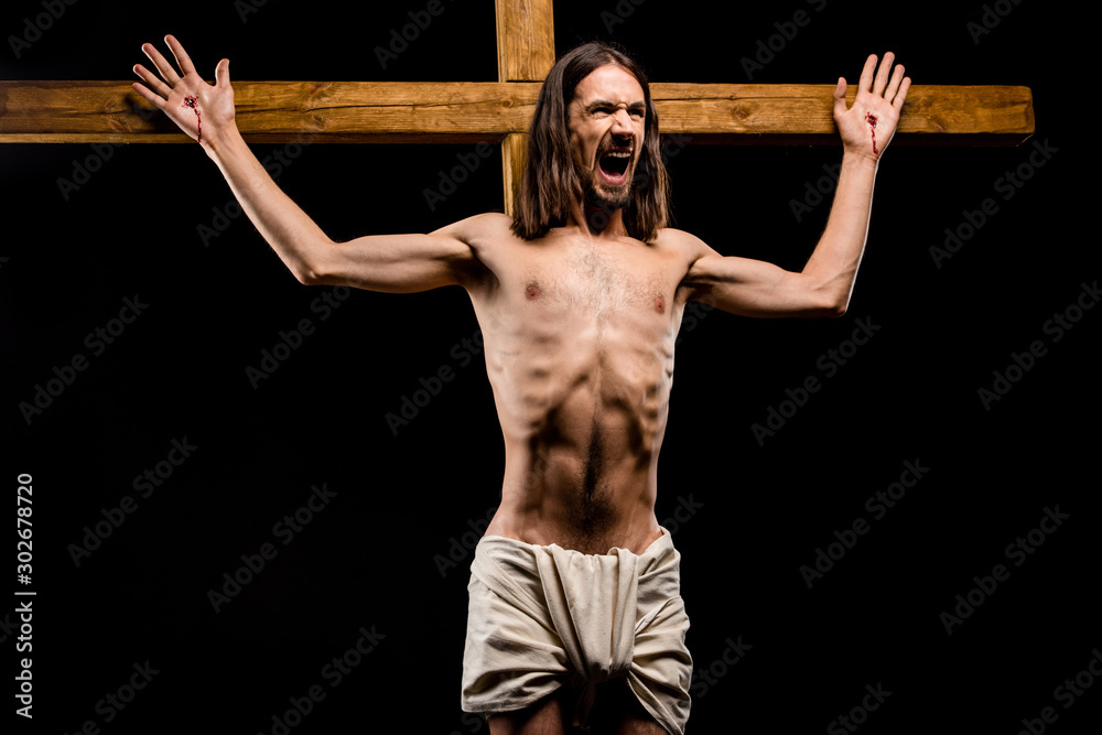 shirtless man crucified on wooden cross screaming isolated on black ...