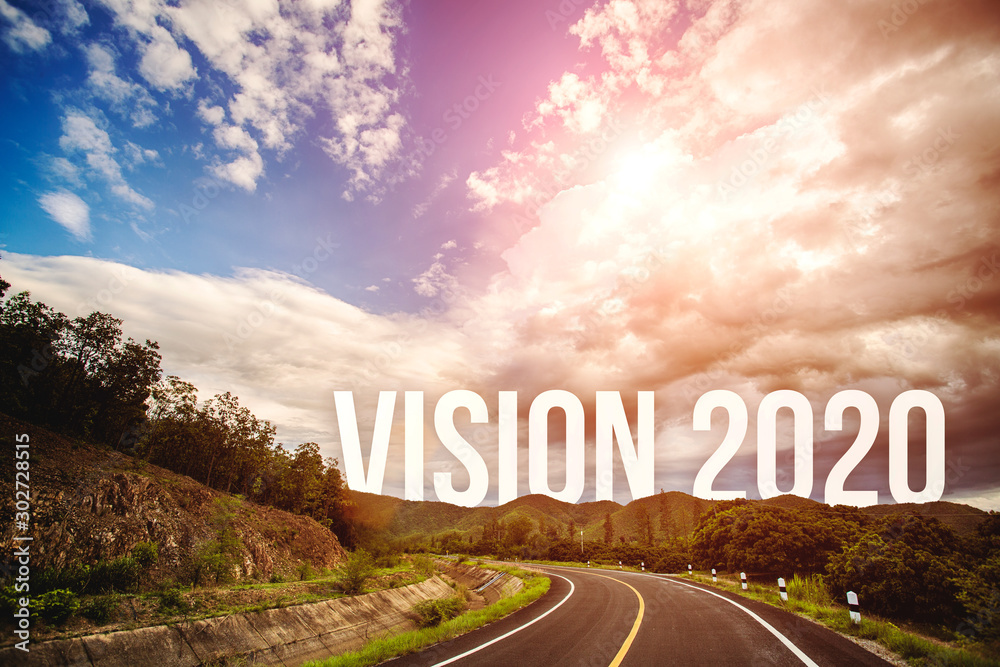 The word vision 2020 behind the tree of empty asphalt road at golden ...