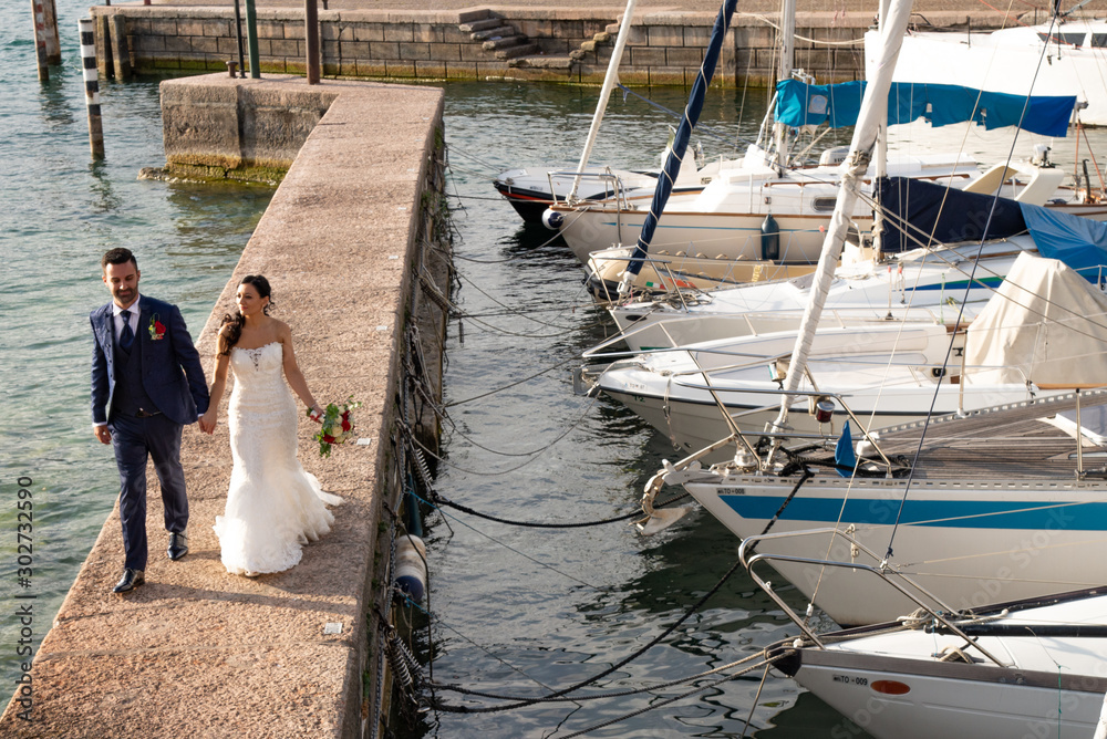 Young married couple strolling at the dock of the lake in Torri del ...