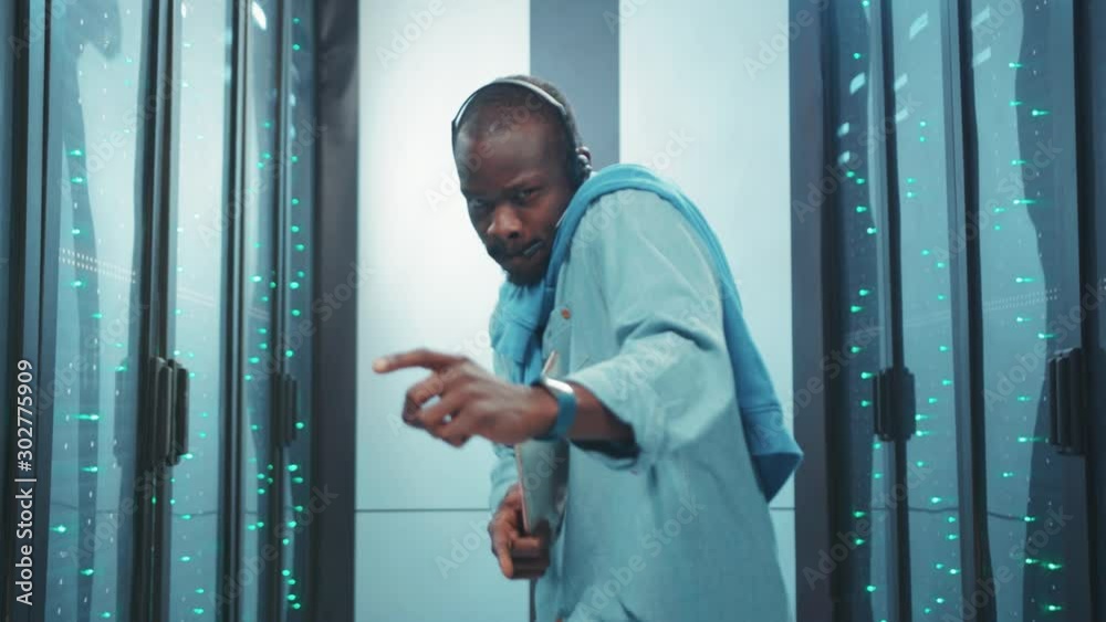 Euphoric african IT administrator having fun at work performing a cool ...