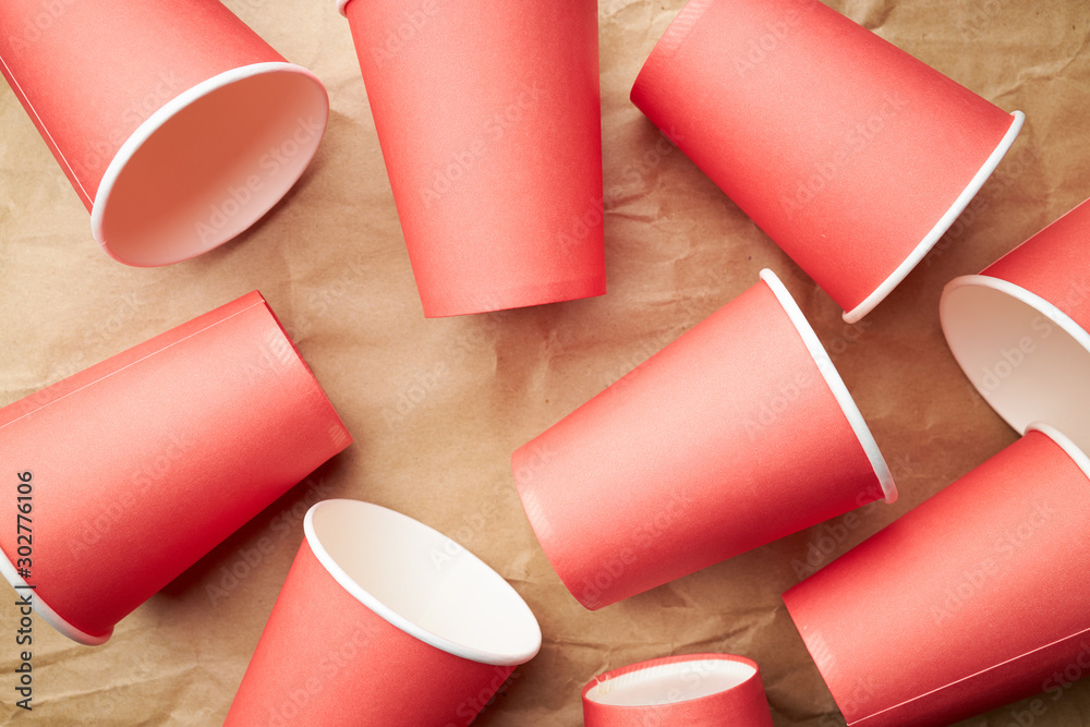 pile of disposable red paper cups on paper background. eco friendly ...
