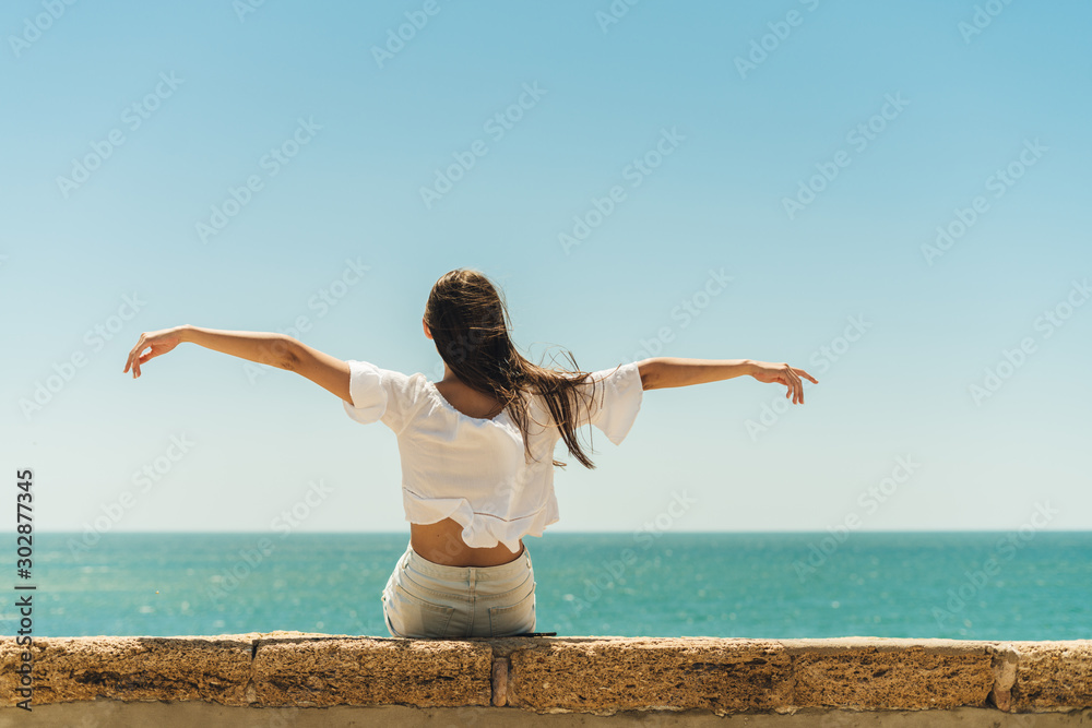 the girl turned her back on the spectator spread her hands to the sides ...
