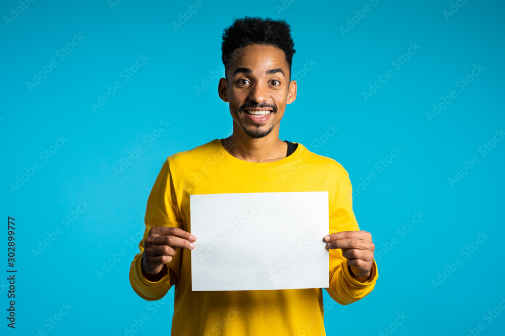 Portrait of young handsome african american man holding white empty ...