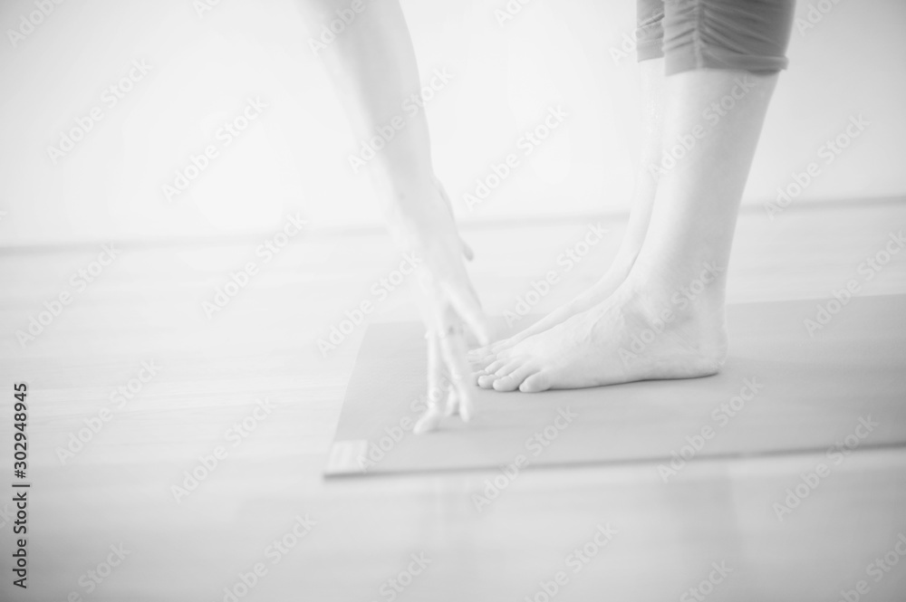 Feet and Hands of A Woman standing in Forward Fold Pose on a yoga mat ...