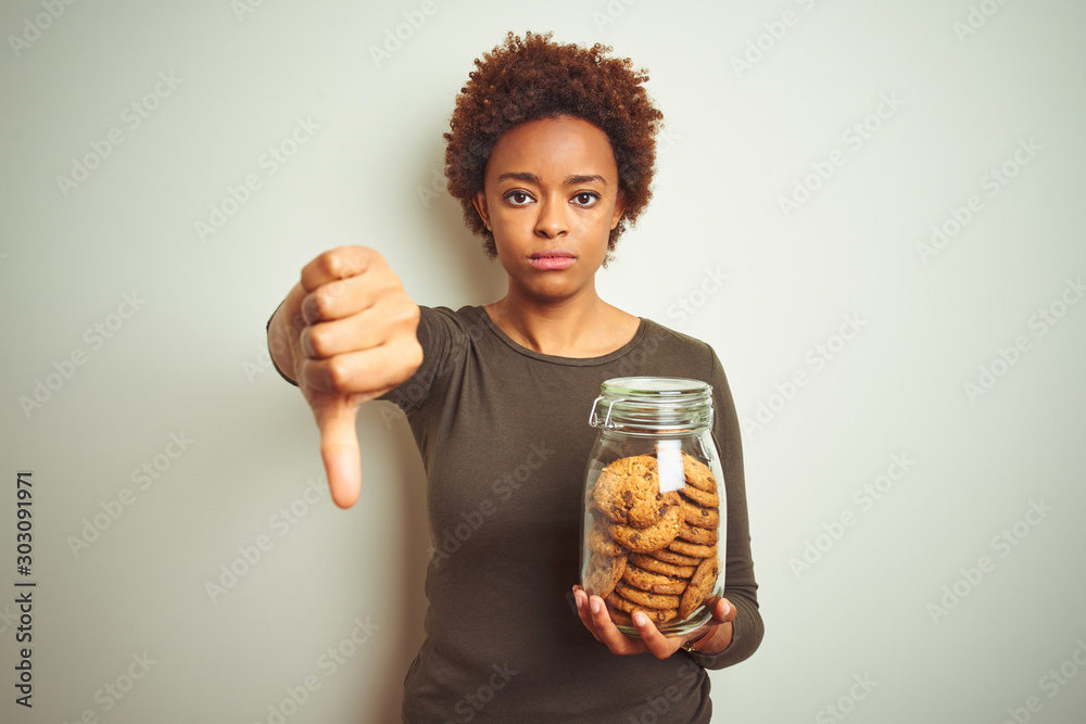 African american woman holding jar of chocolate chips cookies over ...