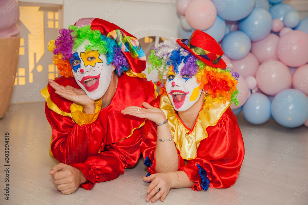 Funny clowns from the circus. Clown boy and clown girl show emotions ...